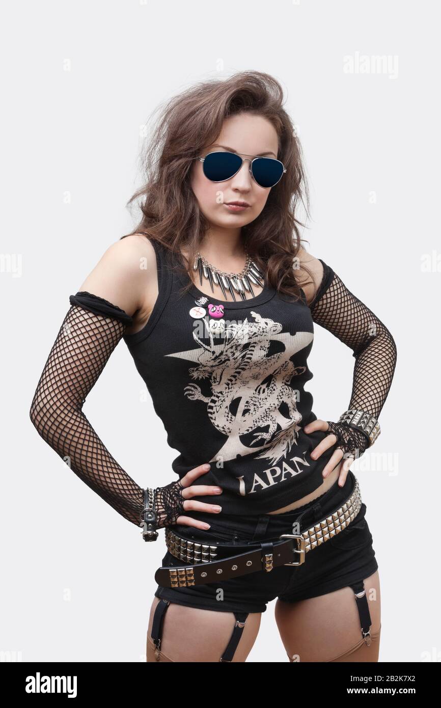Portrait of gothic young woman with hands on hips over white background ...