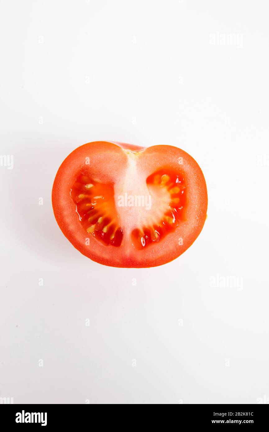 Cross section of tomato over white background Stock Photo - Alamy