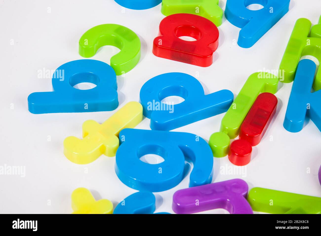 Close-up view of alphabet magnets scattered over white background Stock ...