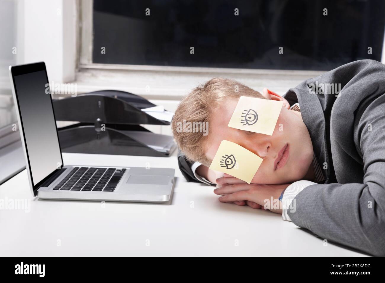 Businessman sleeping with sticky notes on eyes at desk in office Stock ...