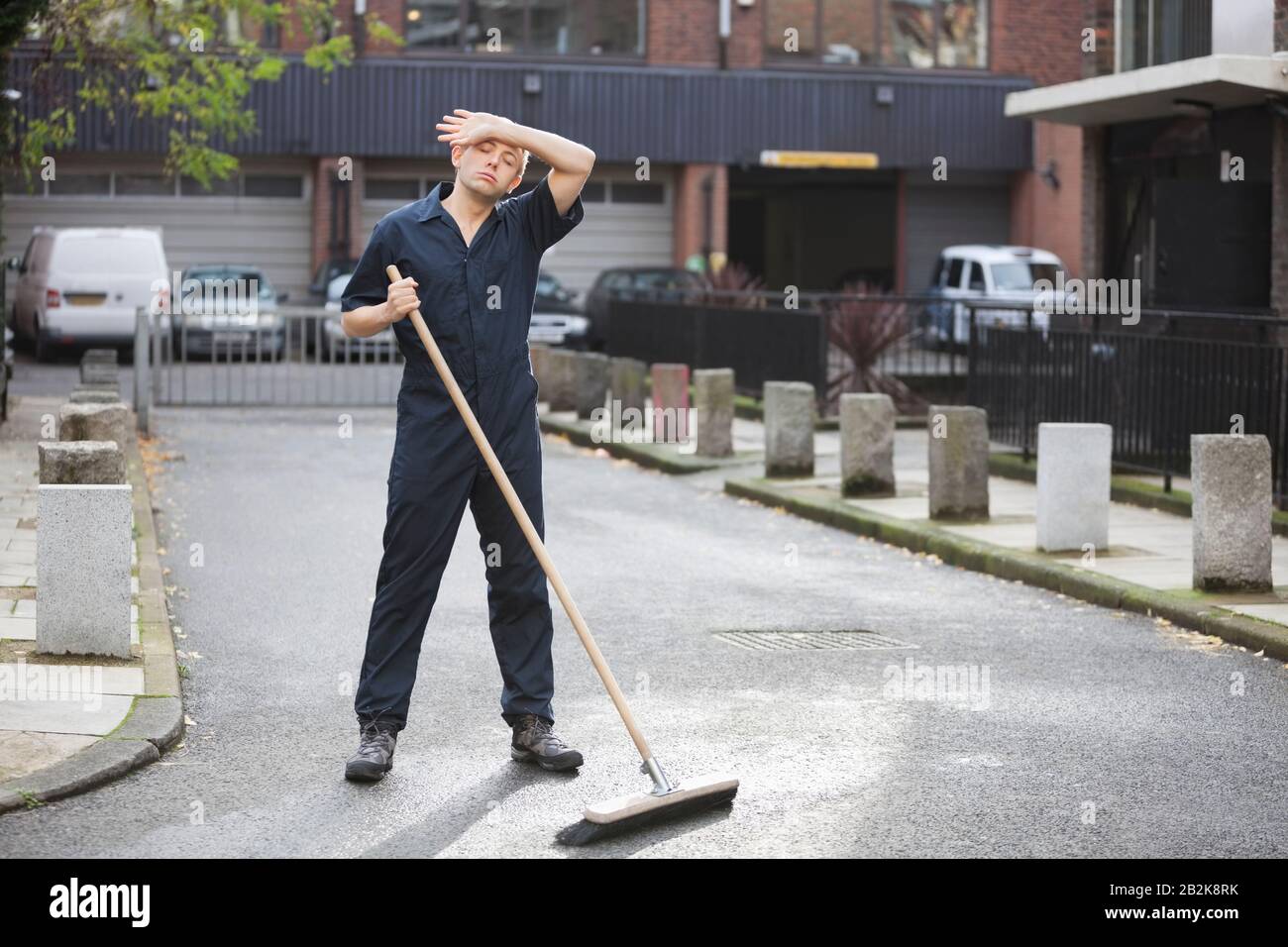 Tired young male street sweeper Stock Photo - Alamy