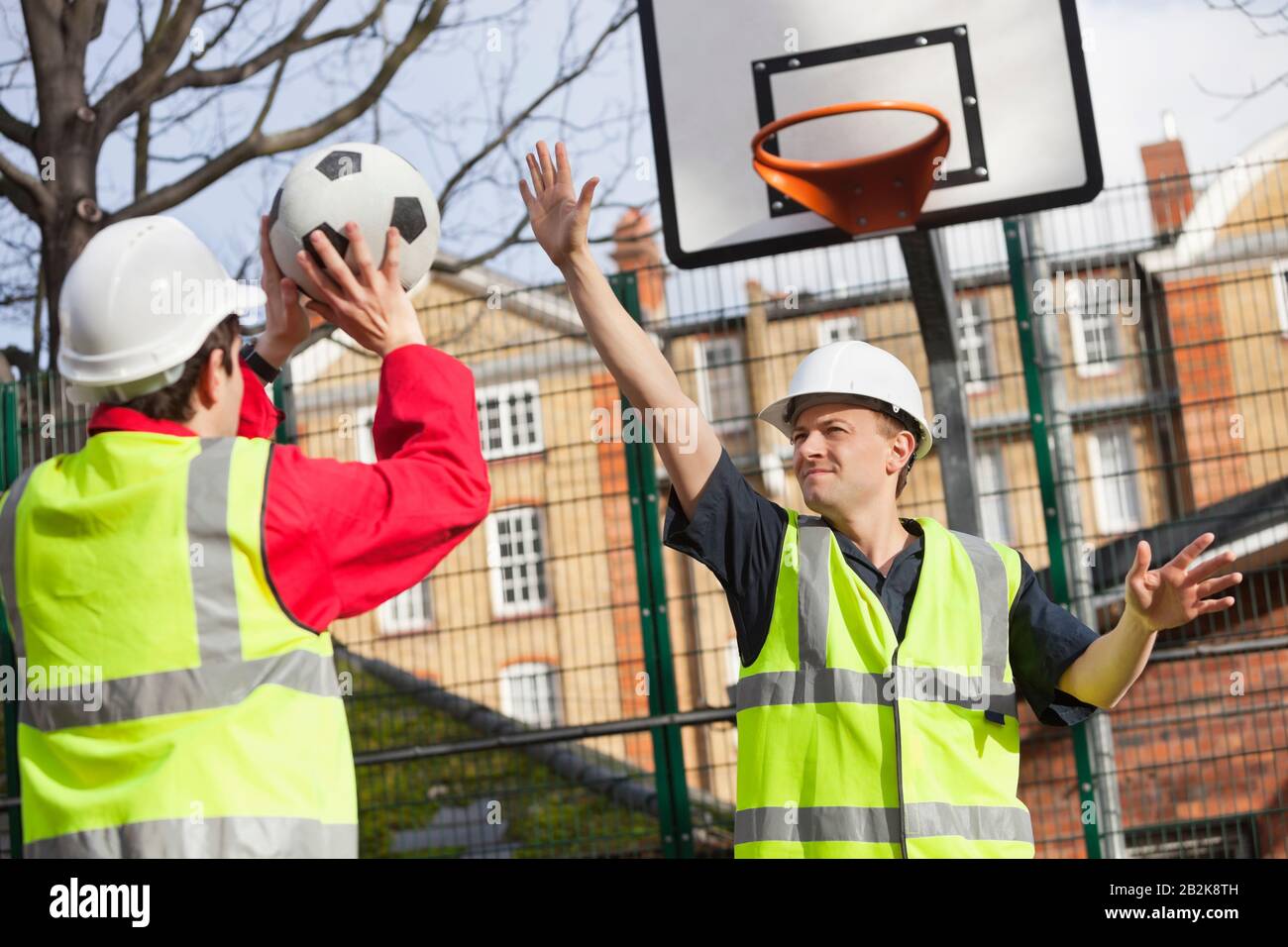 Manual workers playing basketball Stock Photo - Alamy