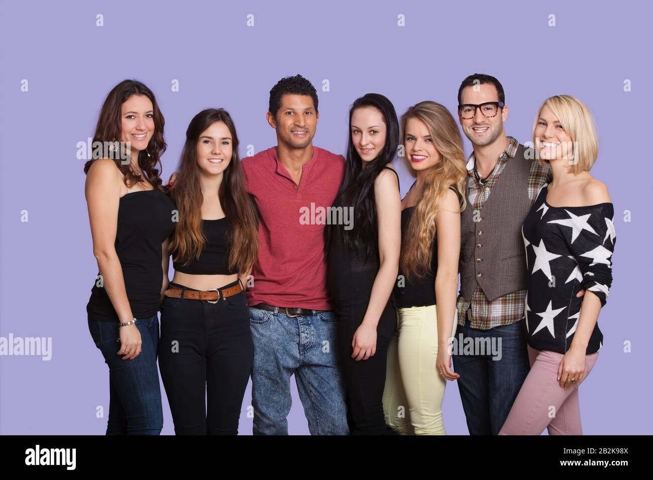 Group portrait of casual multi ethnic friends over purple background ...