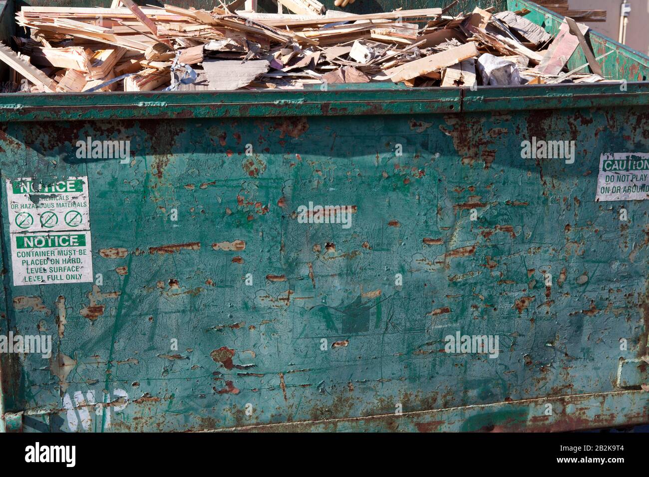 Overflowing dumpster with scrap wood Stock Photo - Alamy