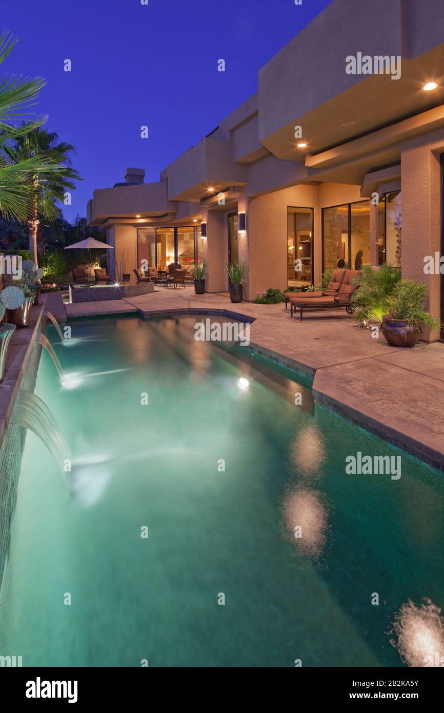 Pool with house exterior at dusk Stock Photo - Alamy