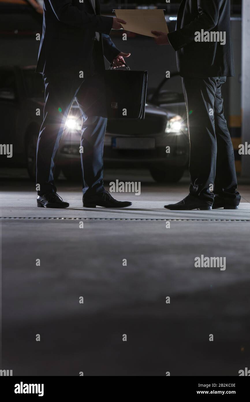 Low section of businesspeople conducting suspicious business in ...