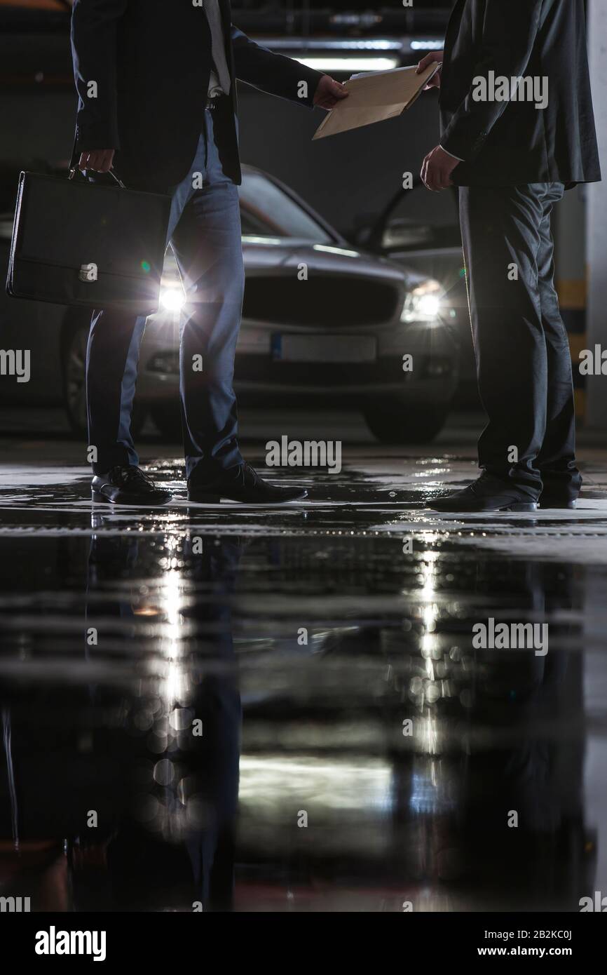 Low section of businesspeople conducting suspicious business in ...