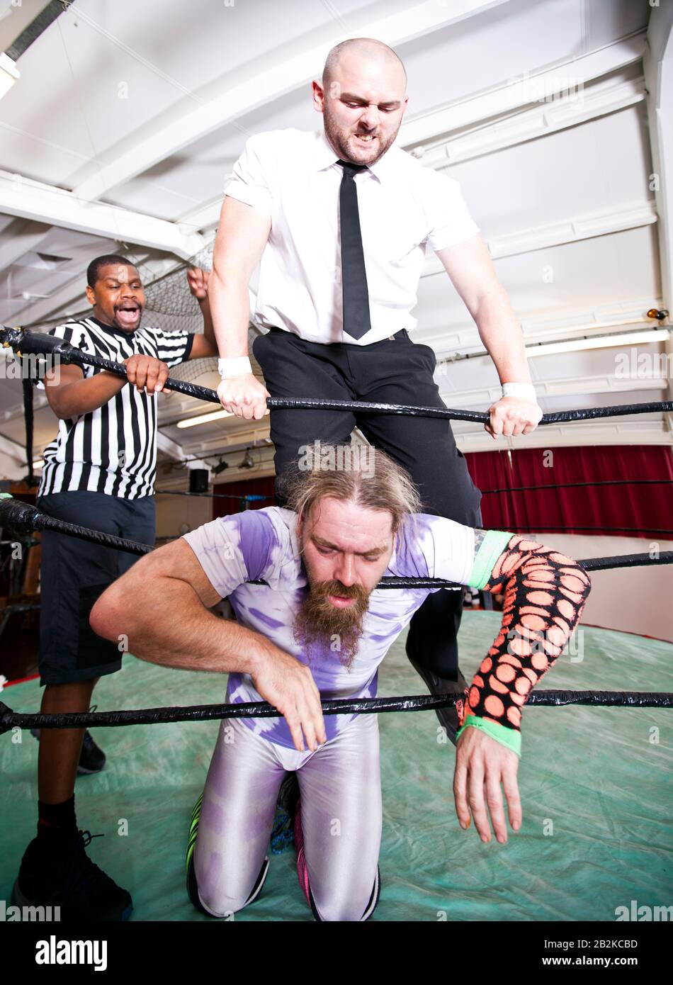 Wrestlers fighting while referee counting during match Stock Photo - Alamy