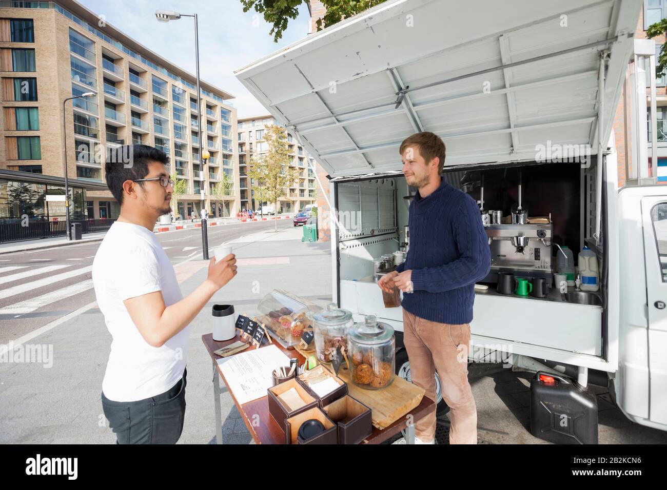 Vendor looking customer at mobile coffee shop on street Stock Photo - Alamy