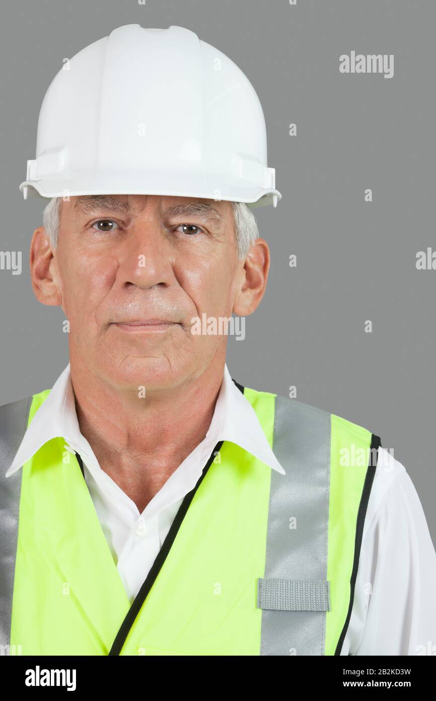 Portrait of male senior construction worker wearing hard hat over white ...