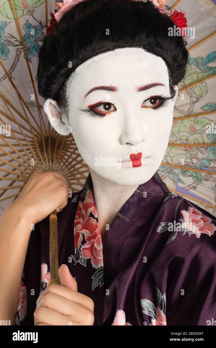 Close-up of Japanese woman with painted face holding parasol Stock ...