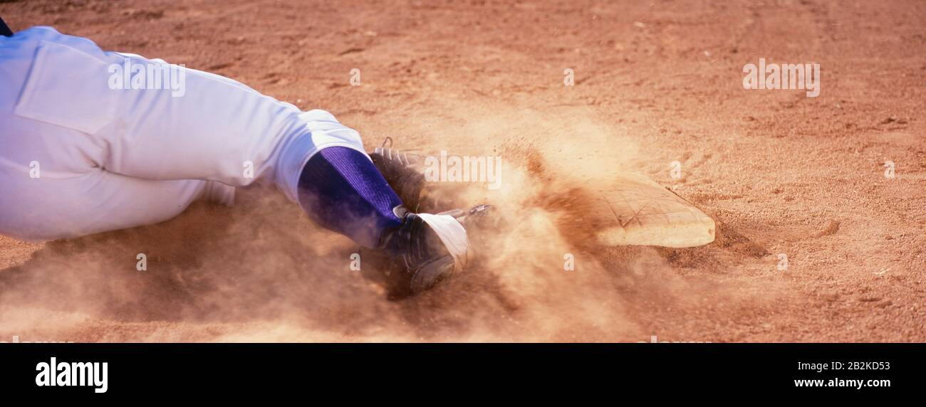Low section of baseball player sliding towards base on field Stock ...