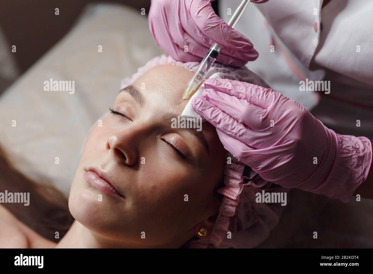 Healthy beautiful skin. Beautician makes beauty shots of a young ...