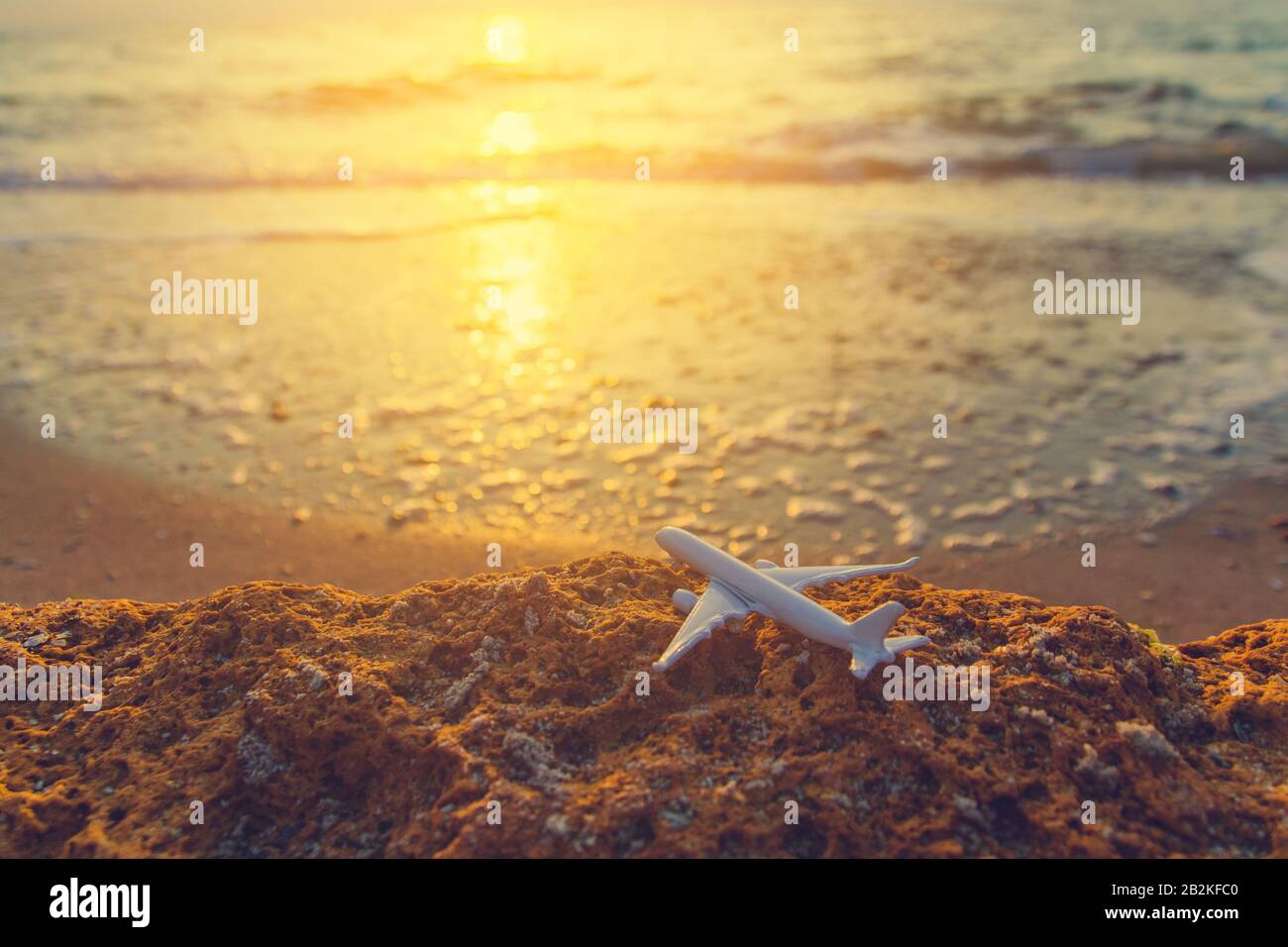 White small airplane model toy on the seashore in the sun. Summer ...