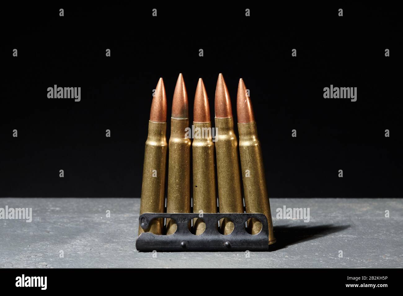 Five rounds of military ammunition with brass cases and copper tips ...