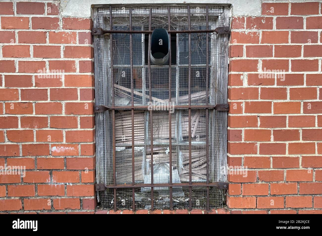 a rusty old steel rod window on a vintage red brick building wall Stock ...