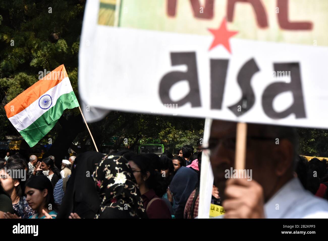 Indian Flag seen at the background of a placard during a protest by ...