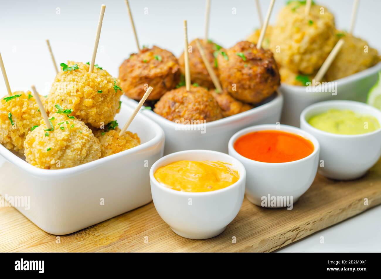 Various mini chicken kievs and sweet potato falafels served with sauces ...