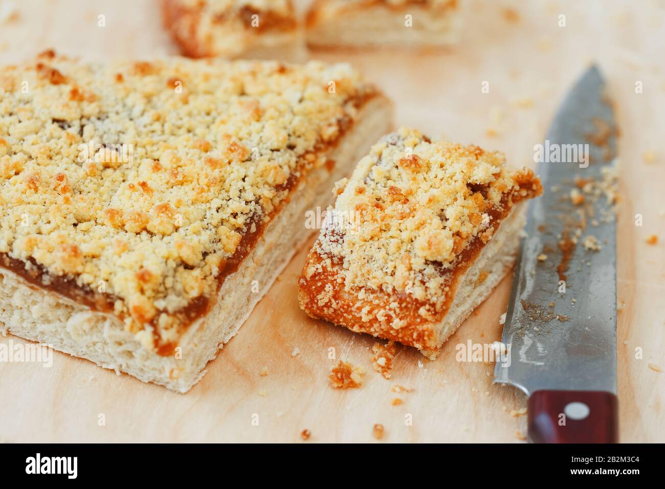 Sweet sand tart with apricot jam. Cut into pieces, lying on a board ...