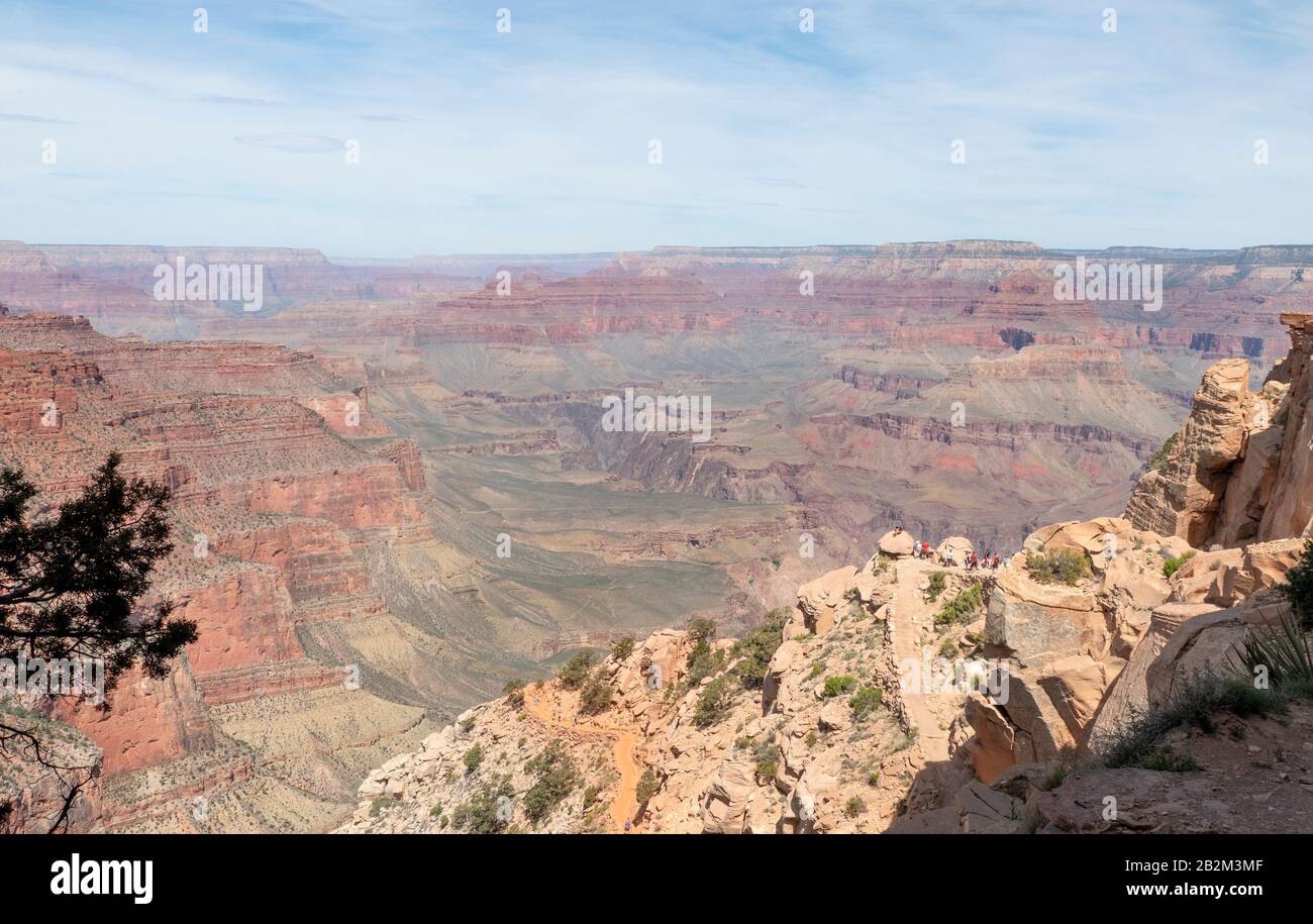 Tourists walk down a cliff path towards the Colorado River in the Grand ...
