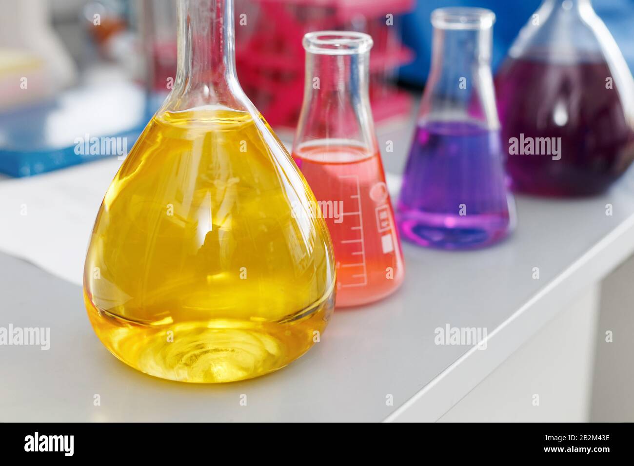 Chemical laboratory flask with blue purple-pink liquid stand on the ...