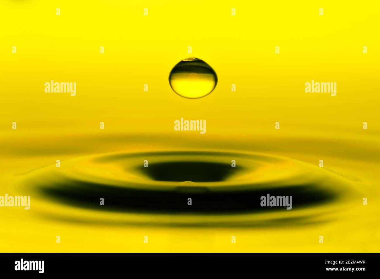 Water Drop Splash On Yellow Background Losing Into Horizon Stock Photo ...