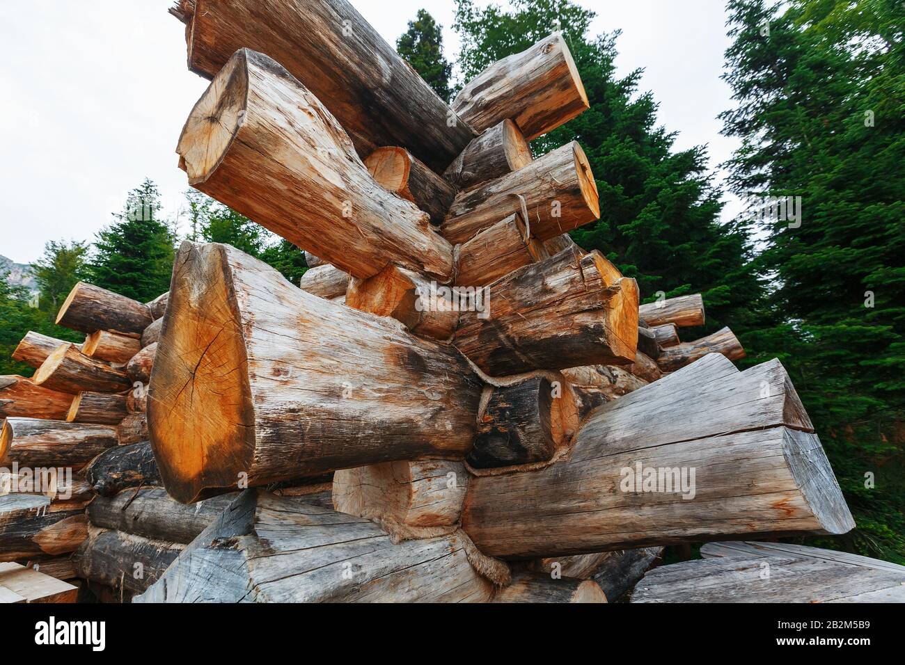 Folded round logs of the facade of an old log cabin, wooden or rustic ...