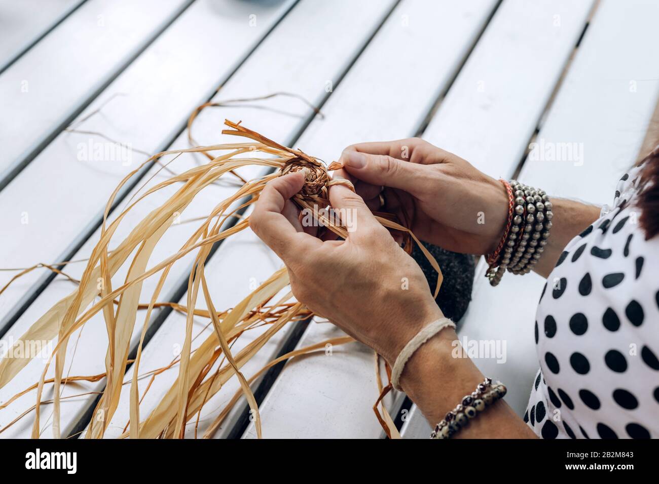 Female weaving basket on the craft workshop. Hands holding the ...