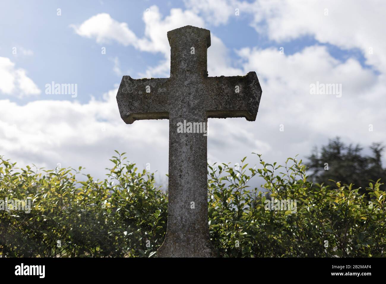 grey grave stone cross standing alone in Cemetery, blue sky background ...