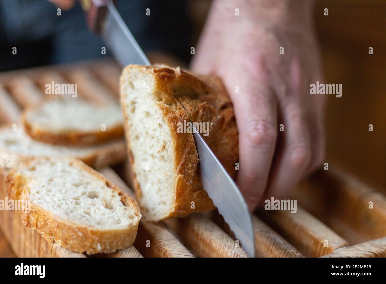 fresh bread cut with knife, wooden board for bread, sliced white whole ...