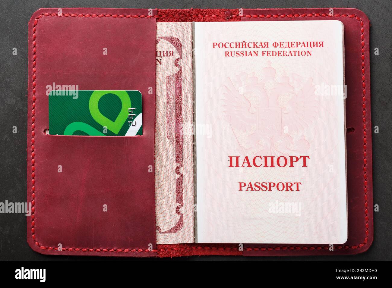 Red handmade passport cover made of genuine leather on a dark ...