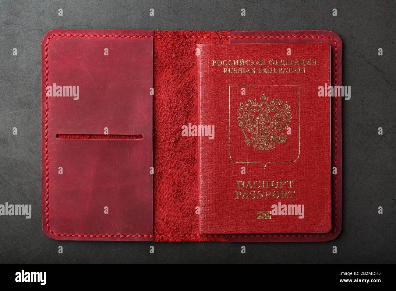 Red passport cover made of genuine leather handmade on a dark ...