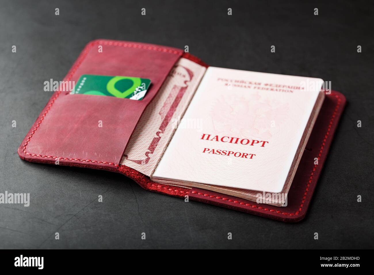 Red handmade passport cover made of genuine leather on a dark ...