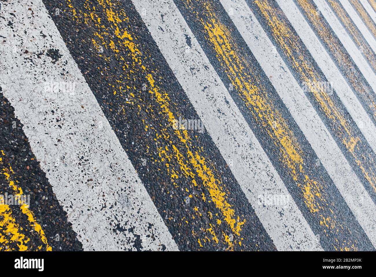Pedestrian crossing, yellow and white stripes on wet asphalt in the ...