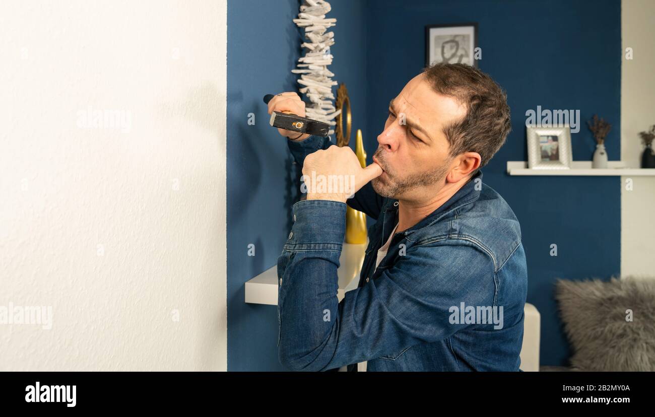 a man hit his finger with a hammer while doing his homework Stock Photo ...