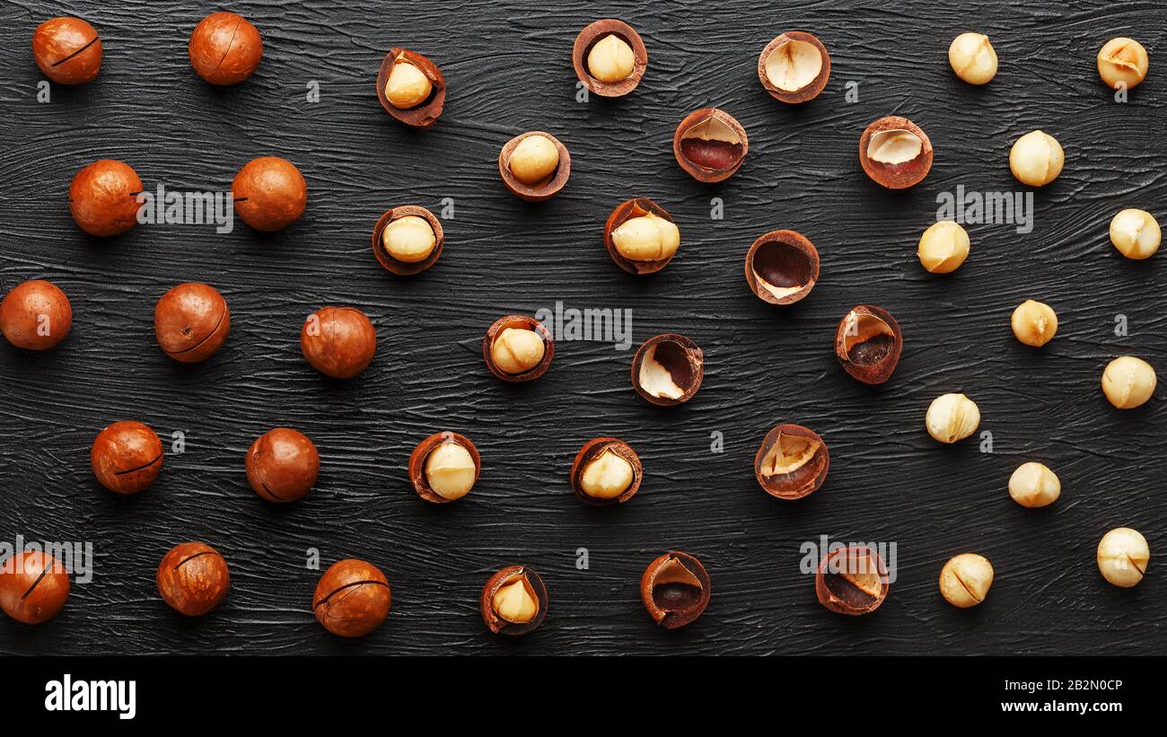 Purified and shell repeats macadamia nuts on black textural stone ...