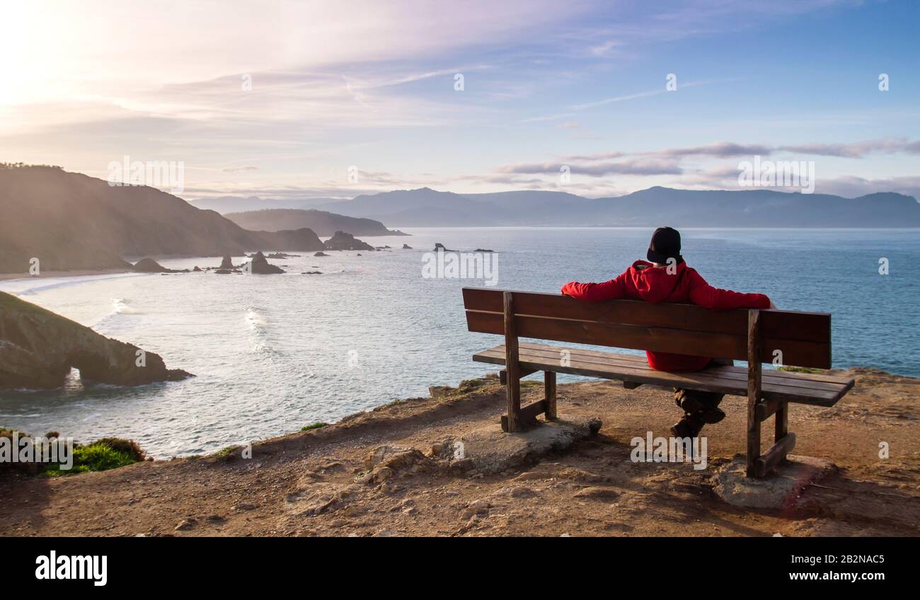 Man relaxing on a woden bench in Loiba Cliffs, Ortigueira, Spain Stock ...