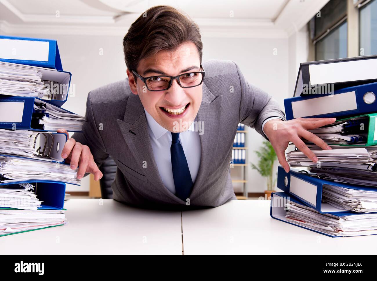 The businessman under stress due to excessive work Stock Photo - Alamy