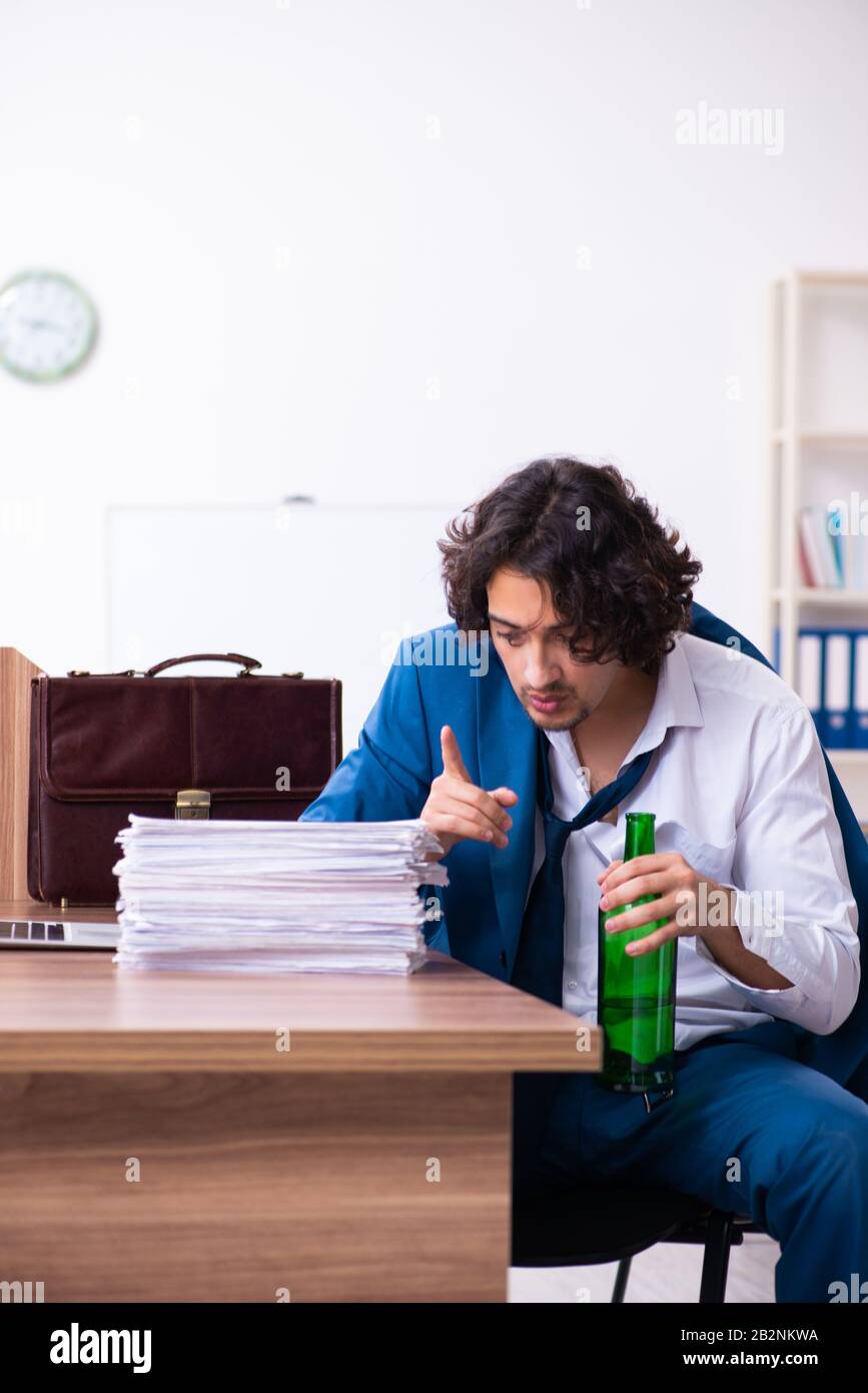 The young drunk employee in the office Stock Photo - Alamy