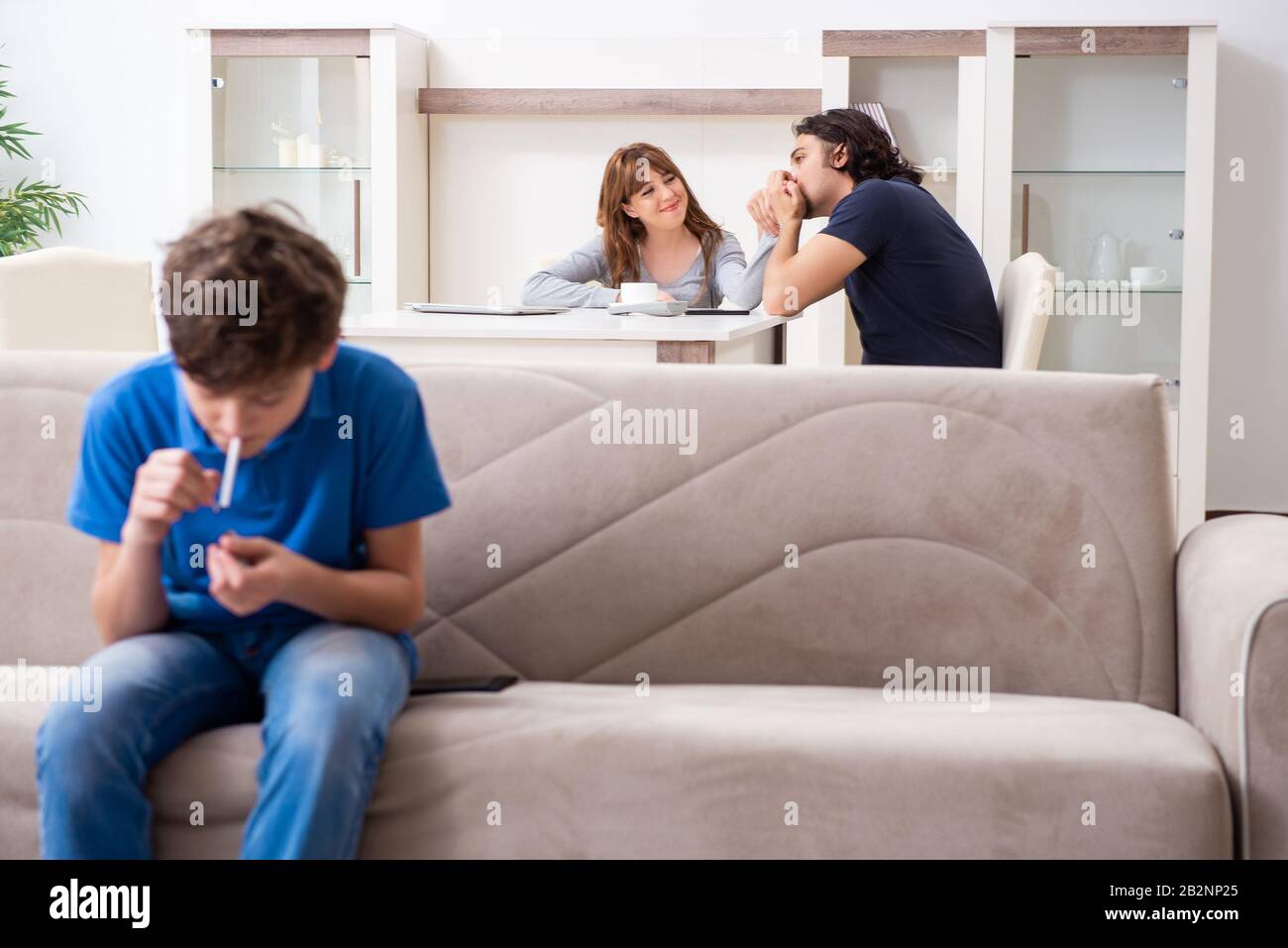 The concept of underage smoking with young boy and family Stock Photo ...