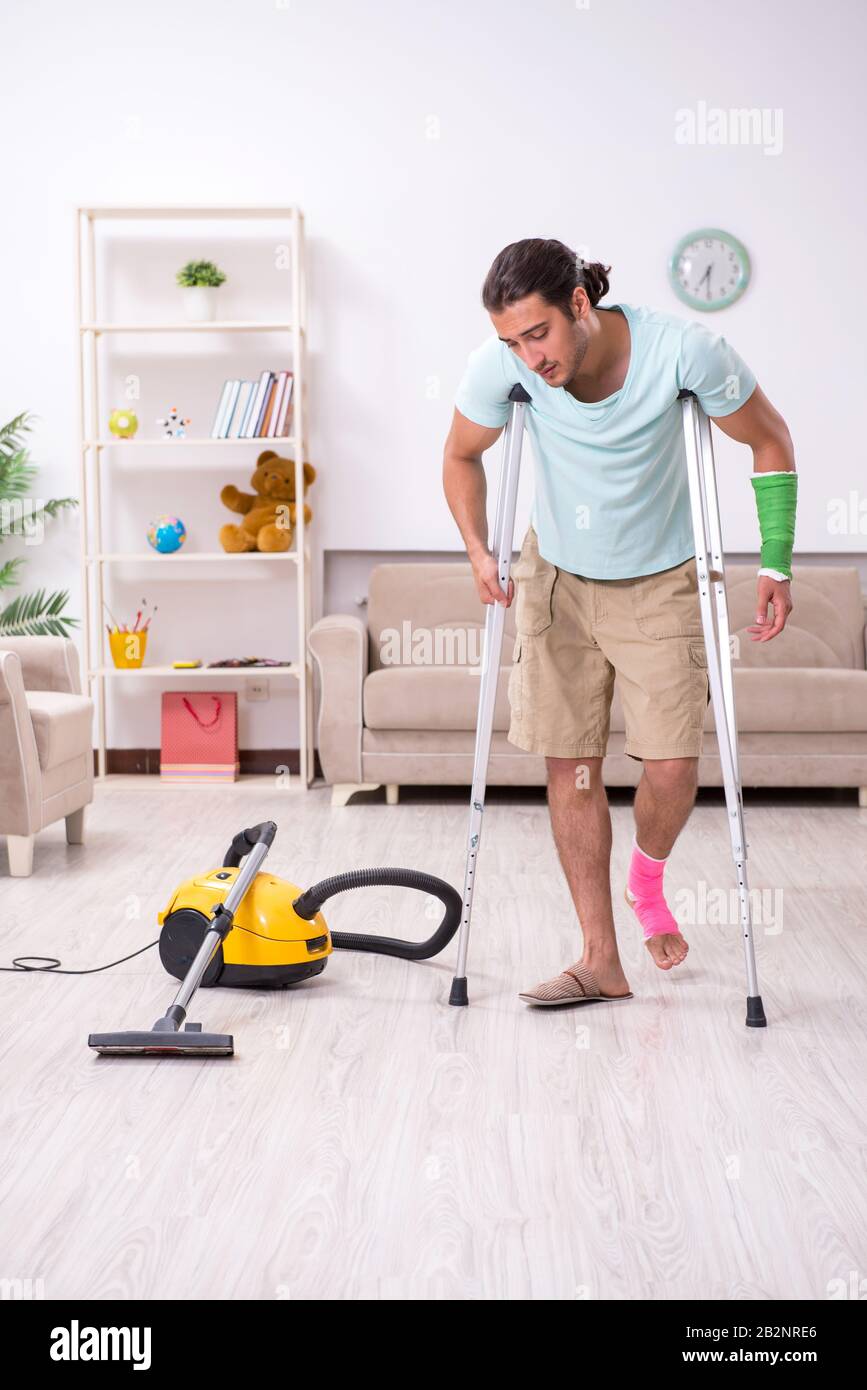 The young injured man cleaning the house Stock Photo - Alamy