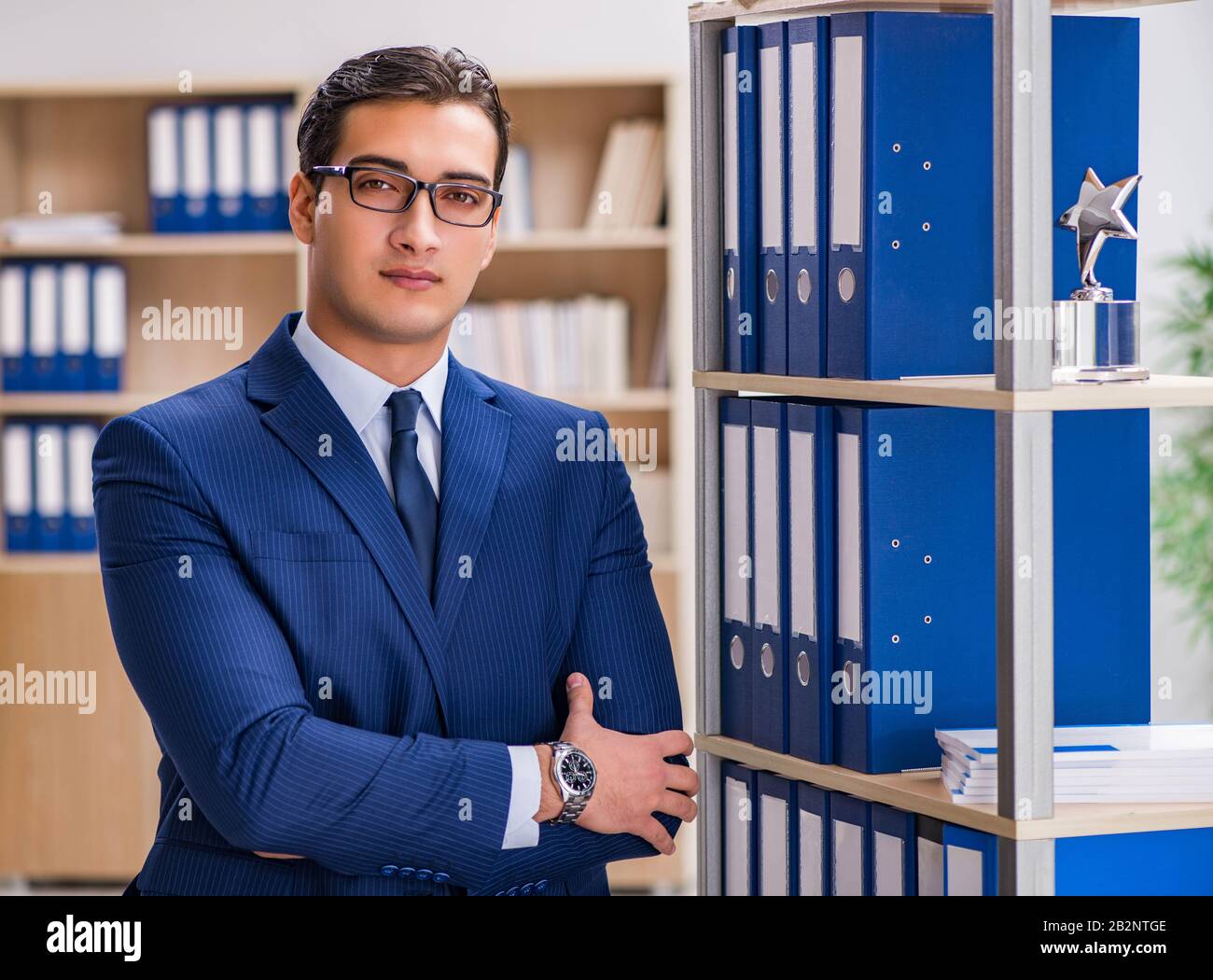 The young man standing next to the shelf with folders Stock Photo - Alamy