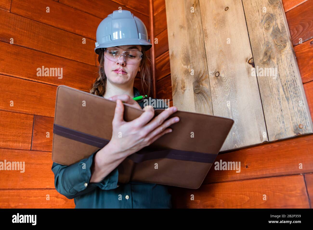 construction female inspector using a clipboard to taking notes. a ...