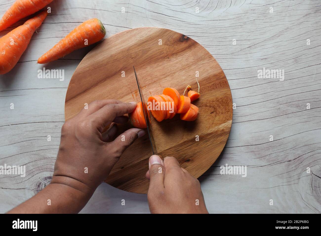 top view of man hand cutting carrot on chopping board Stock Photo - Alamy