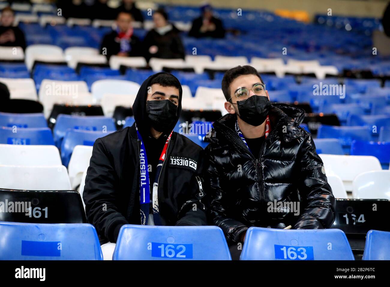 Two fans in the stands wearing face masks prior to the beginning of the ...