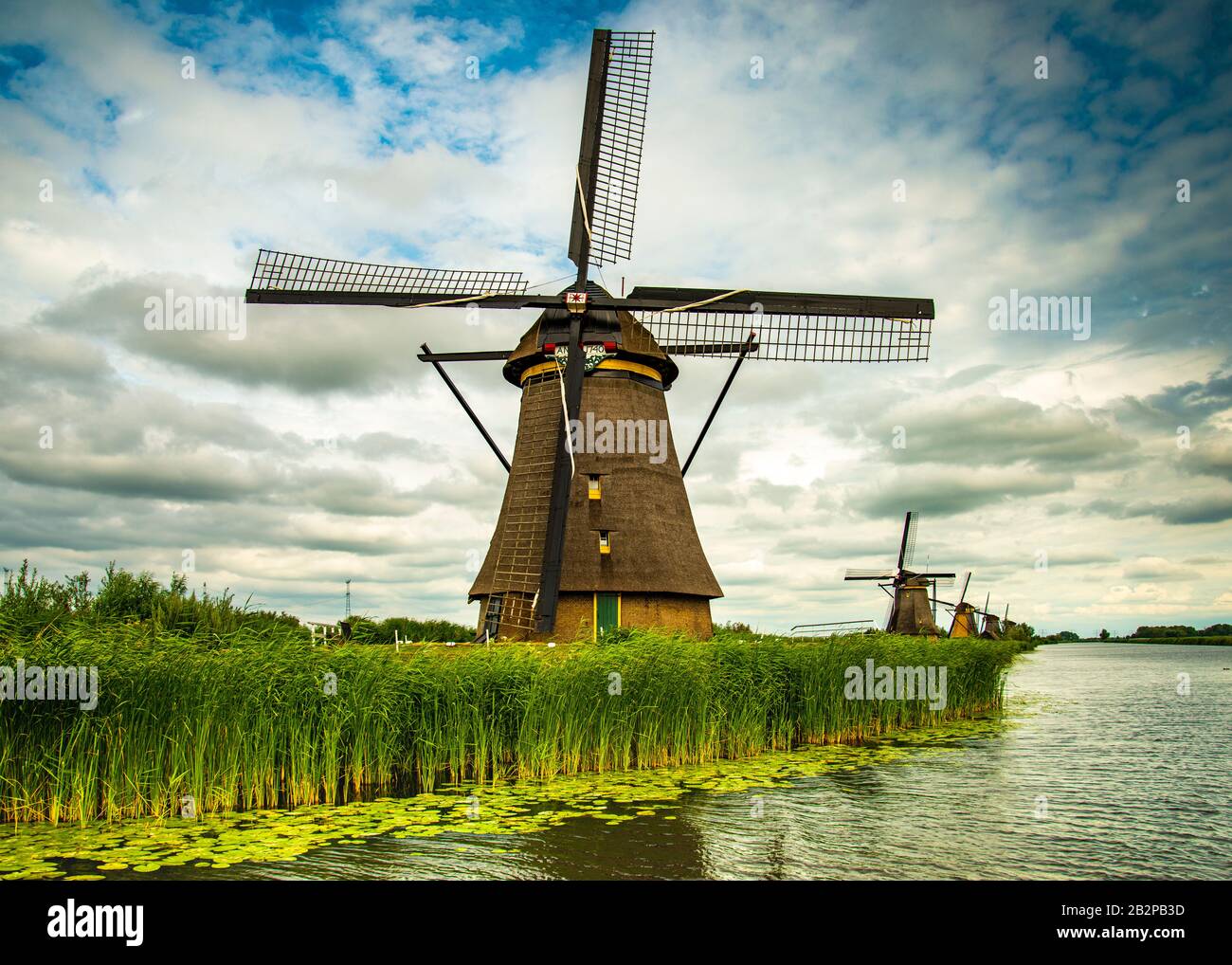 traditional dutch windmills on the canal bank lined up reducing into ...