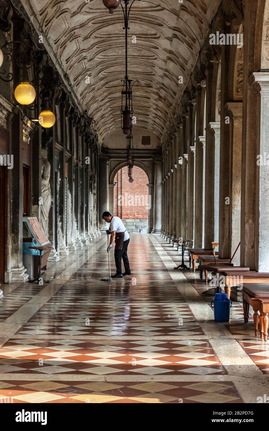 Worker mopping outside cafe, St Mark's Square, Venice, Italy Stock ...