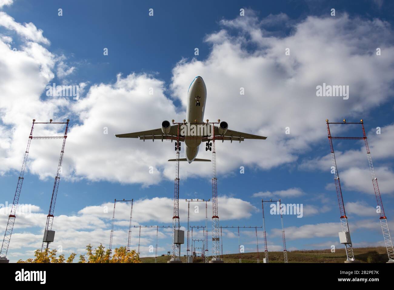 Large aircraft seen overhead landing over runway approach lights on a ...