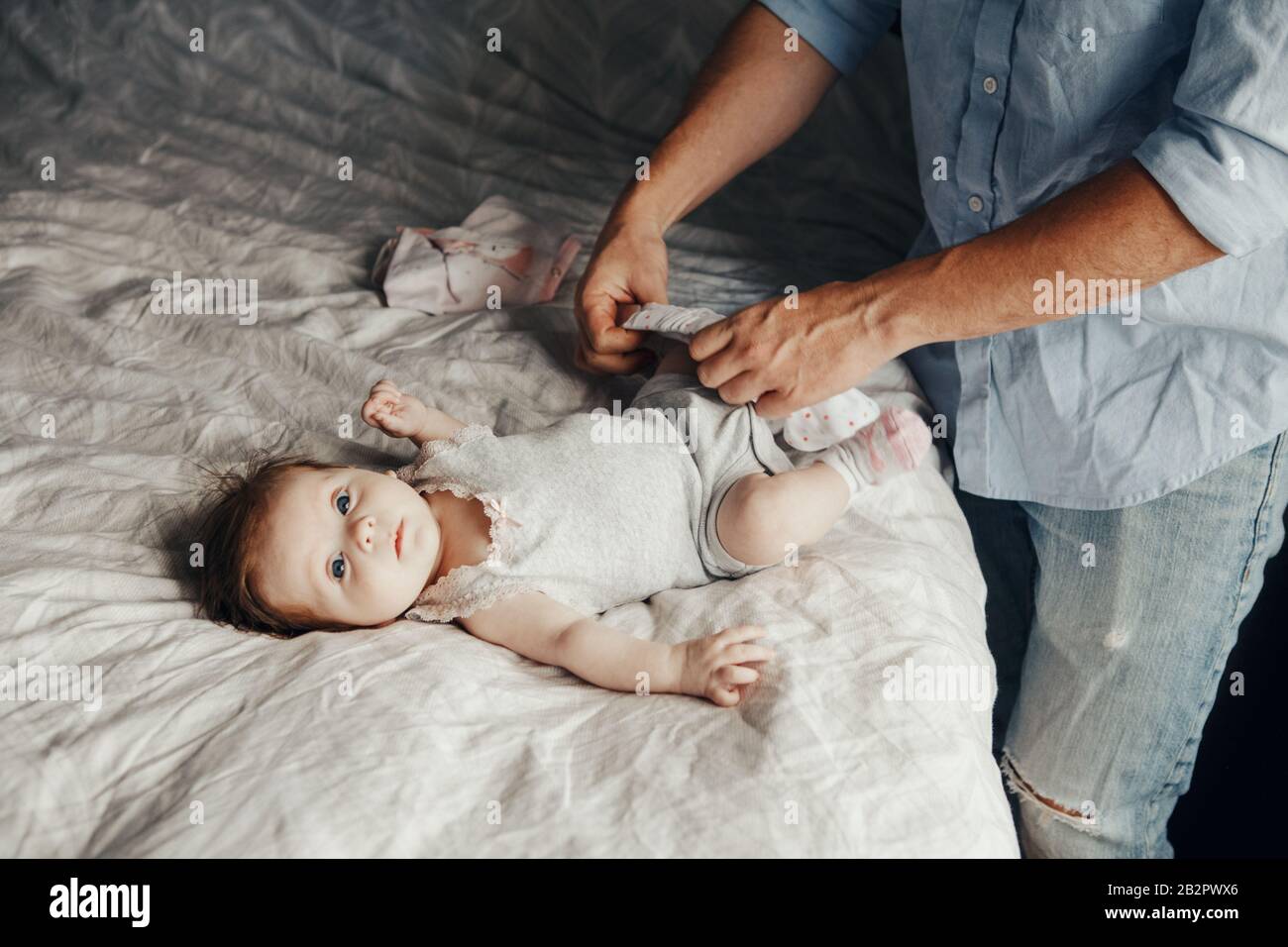 Father changing diaper put on clothes for newborn daughter. Cute baby ...