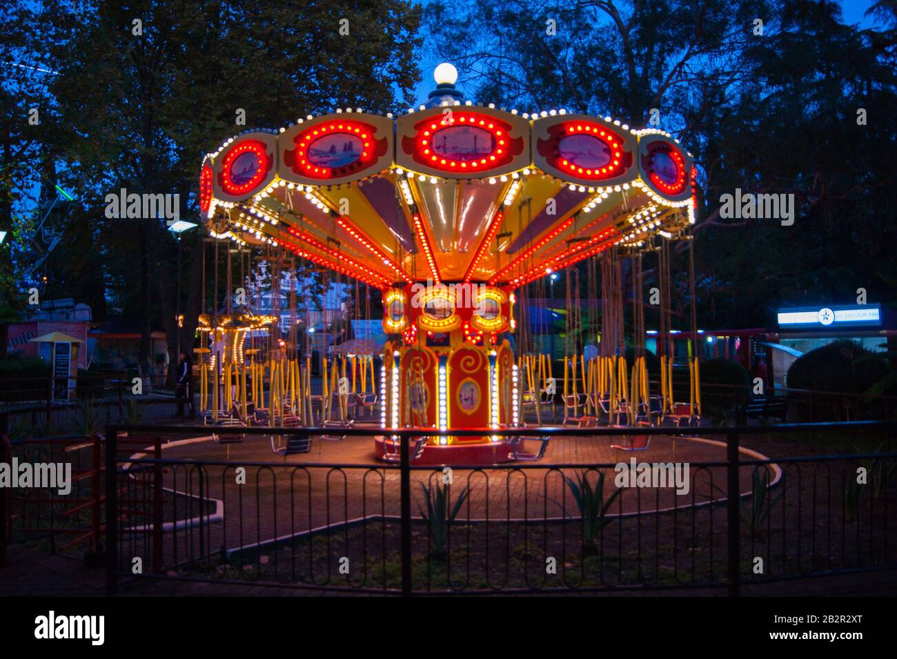 Carousel in bright lights on a dark summer south night against a ...